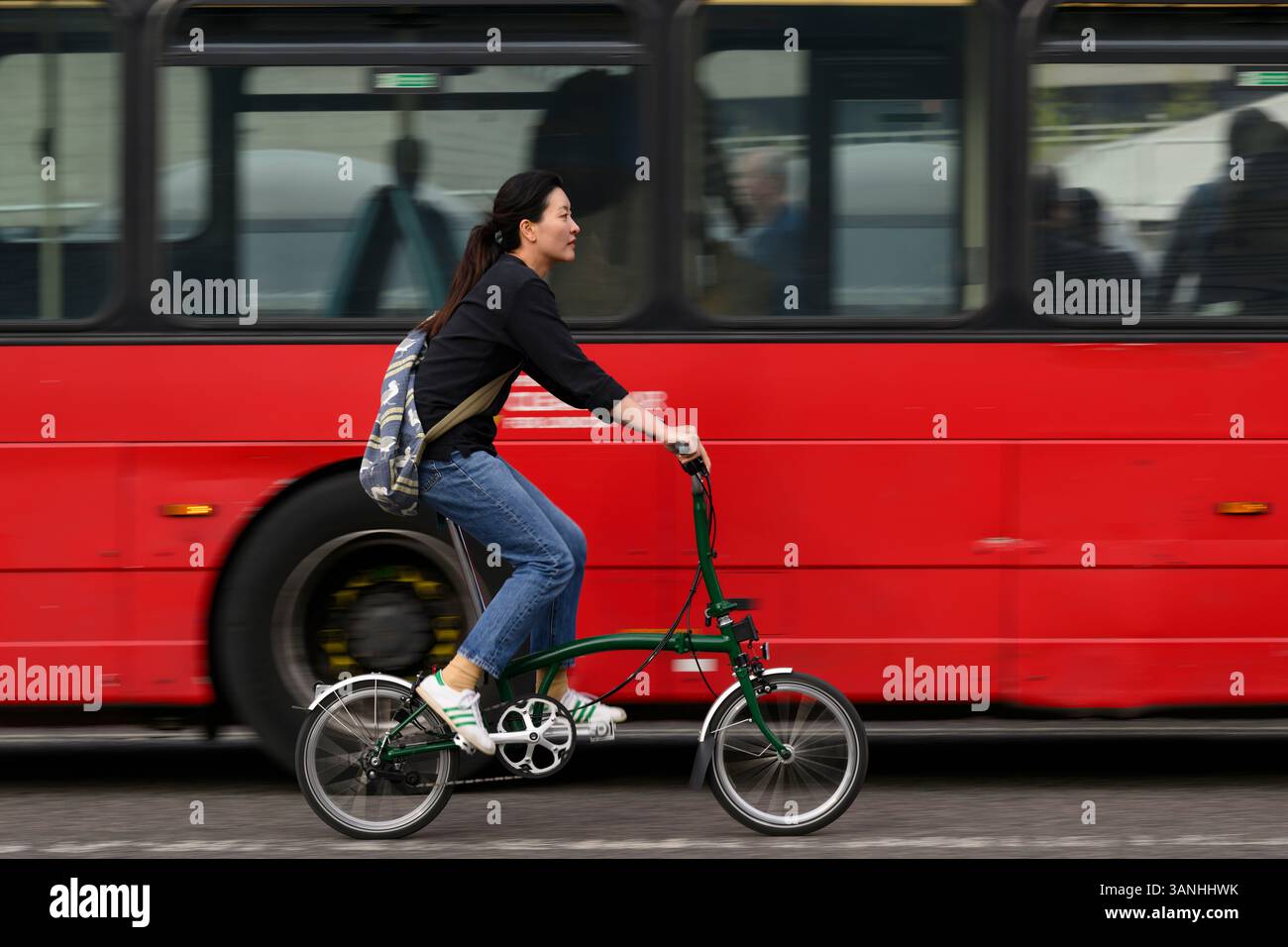 A woman is riding a Brompton folding bicycle across Waterloo Bridge ...