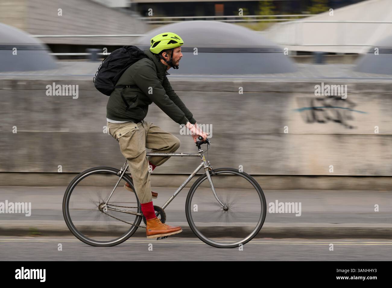 A man cycling a single speed bicycle across Waterloo Bridge, London, UK ...