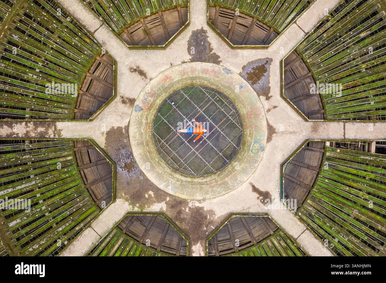 Aerial view of a man laying down on the floor of an abandoned Power ...