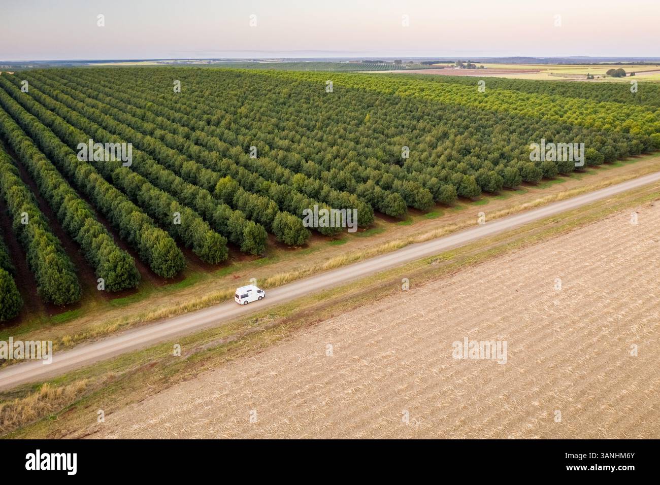 Aerial view of a white camper van driving a straight road along an ...