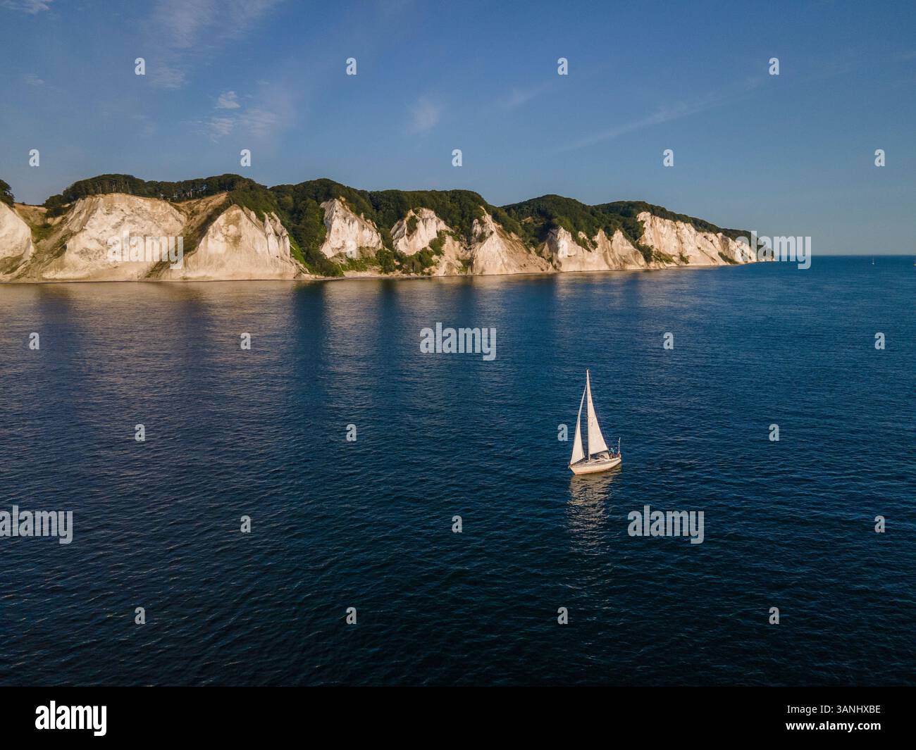 Aerial view of sailboat on a clear and sunny morning near the white ...