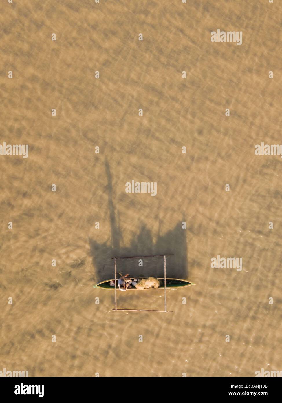 Aerial view of a fisherman and his mirror shadow fishing using a ...
