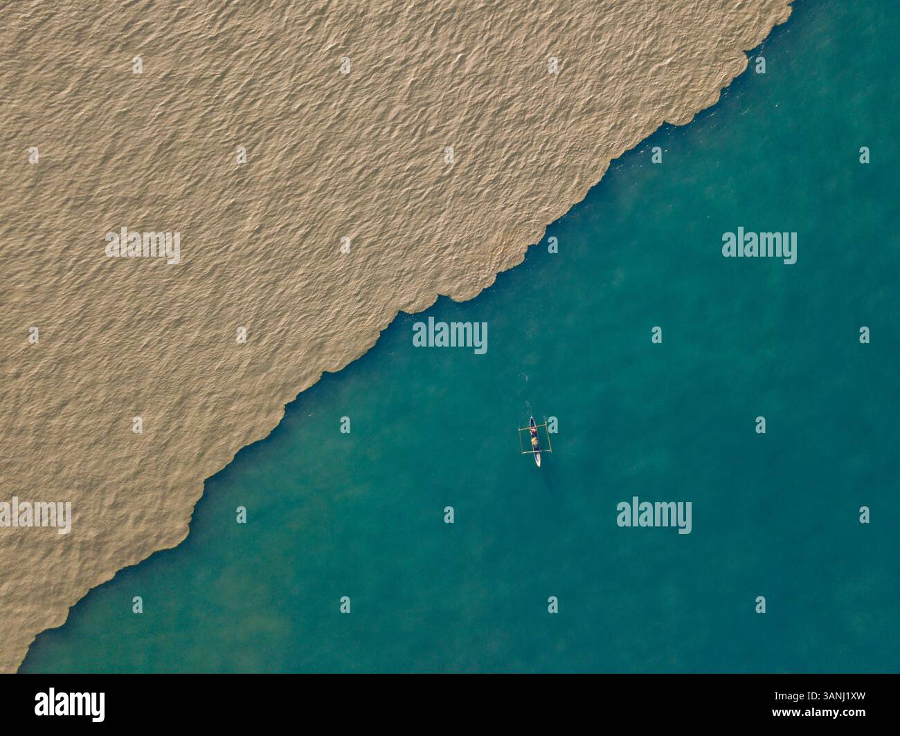 Aerial view of a fisherman fishing in the mouth of the muddy Comoro ...