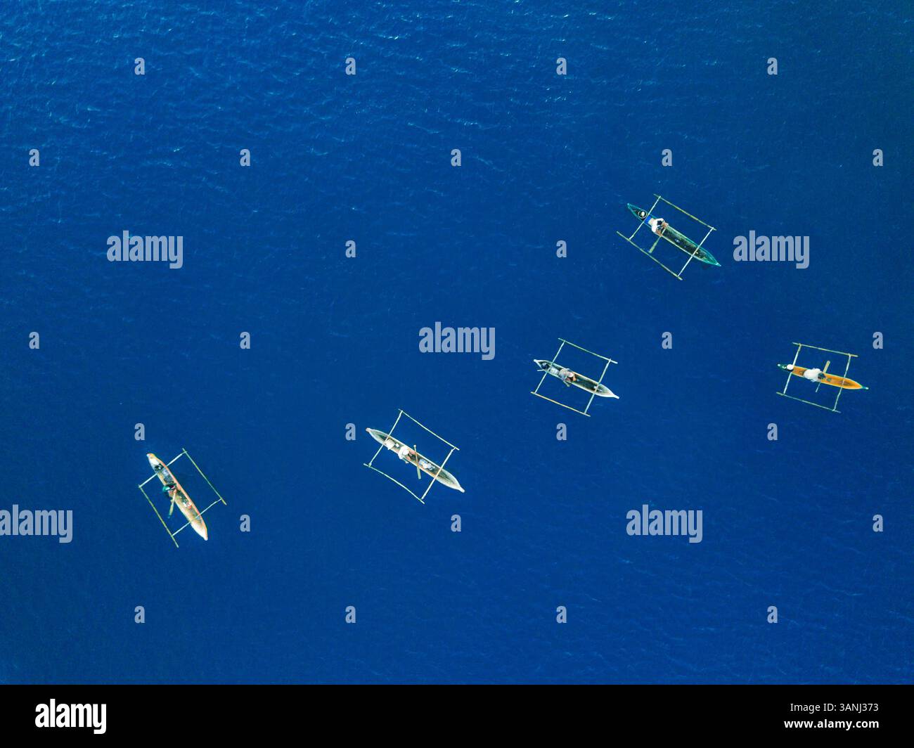 Aerial view of fishermen fishing using pirogue boats on deep blue ocean ...
