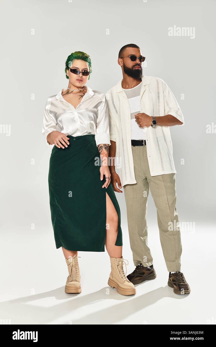 A multicultural couple poses fashionably in sunglasses, showcasing ...