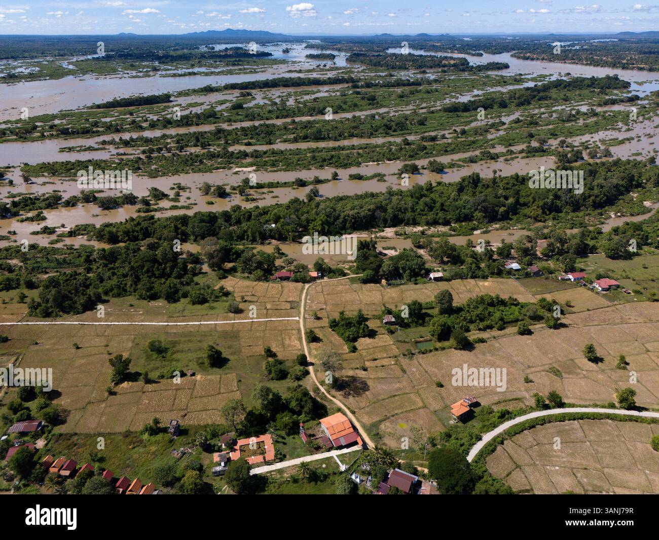 Aerial view of serene rural landscape with a river, fields, and village ...