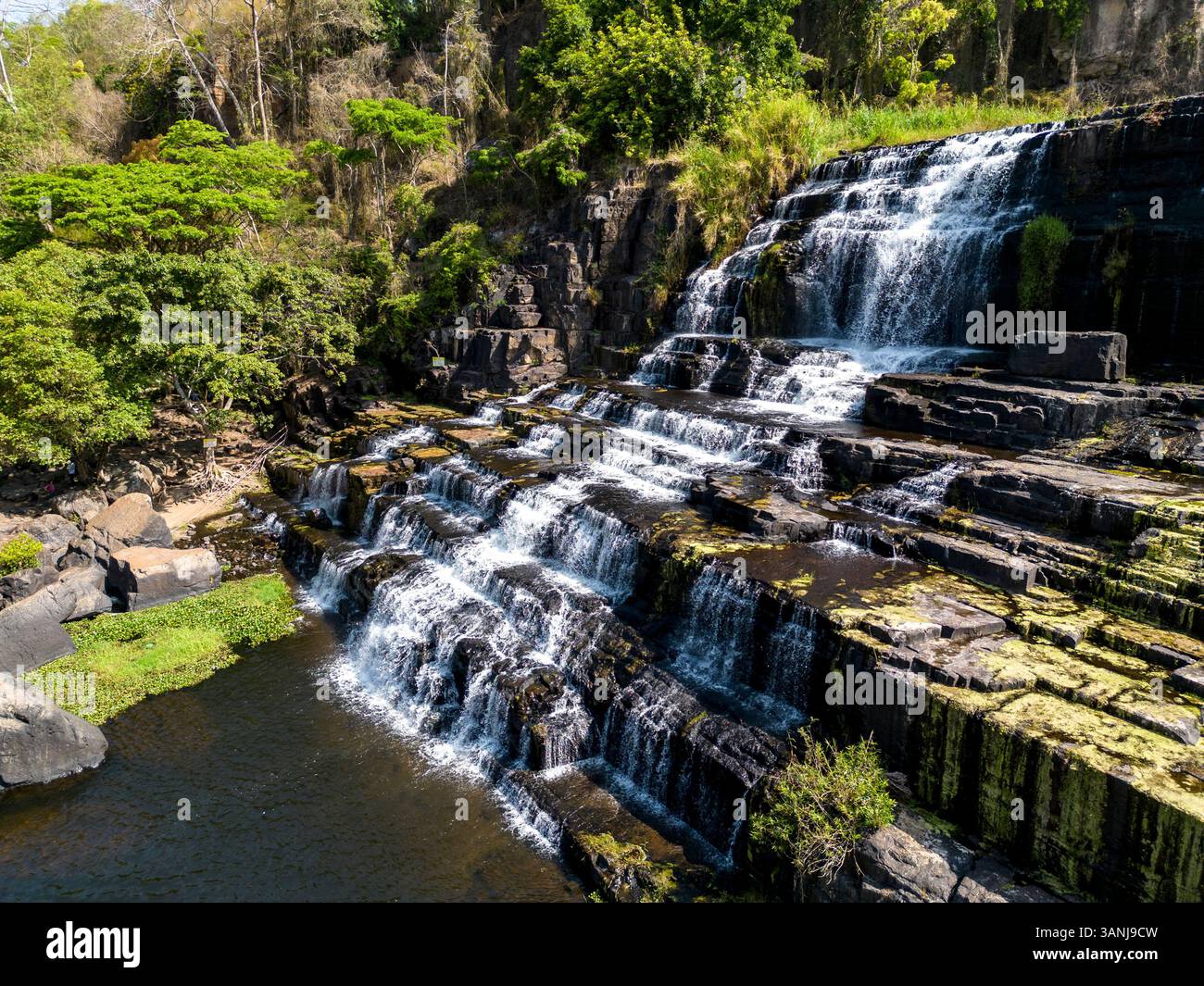 Aerial view of a picturesque waterfall cascading over rocks surrounded ...
