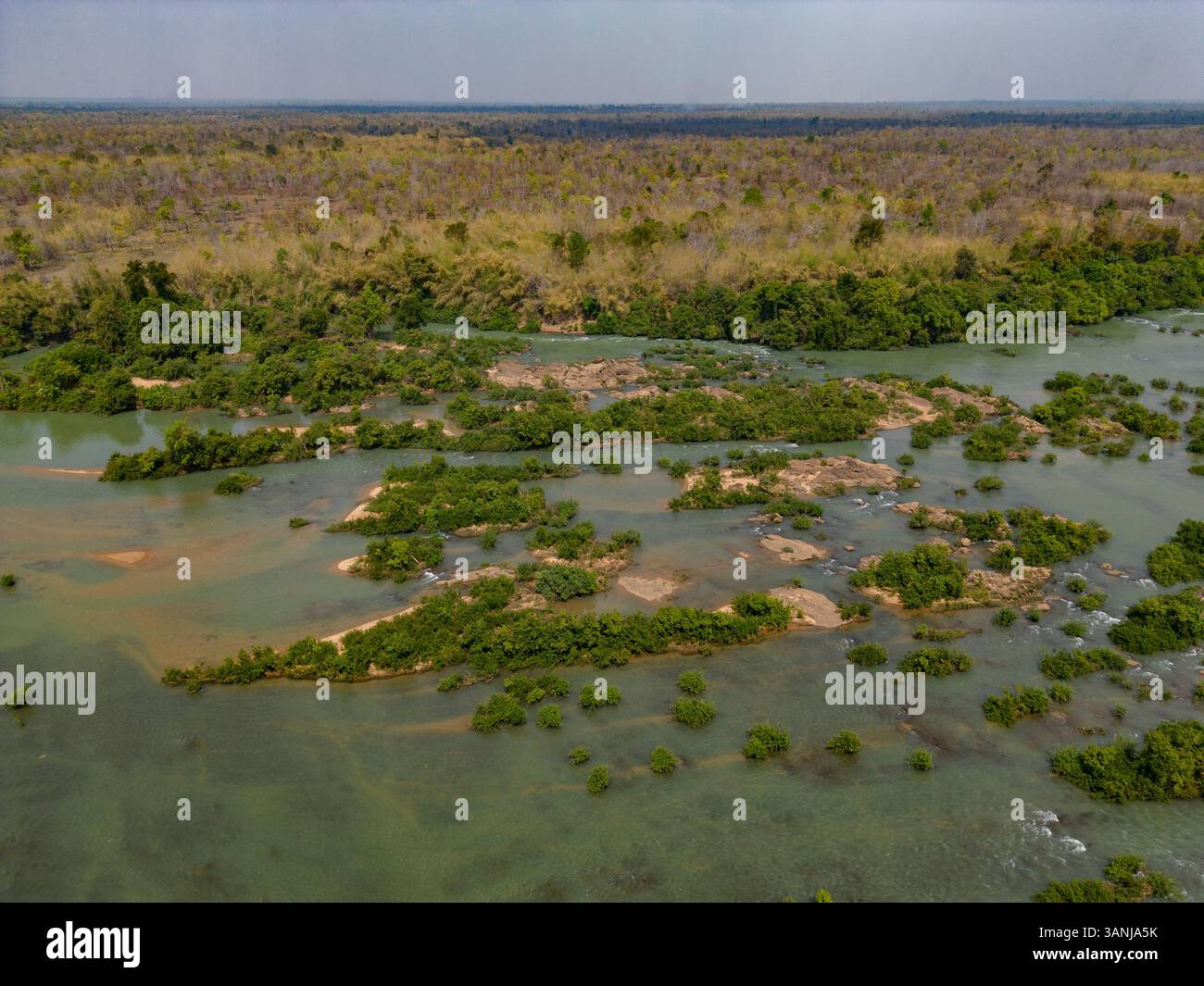 Aerial view of the serene Srepok river surrounded by lush greenery and ...