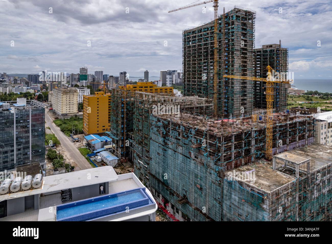 Aerial view of unfinished buildings and cranes in a modern cityscape ...