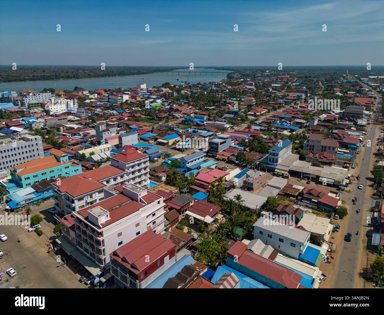Aerial view of colorful cityscape with rooftops and streets along the river, Stung Treng ...