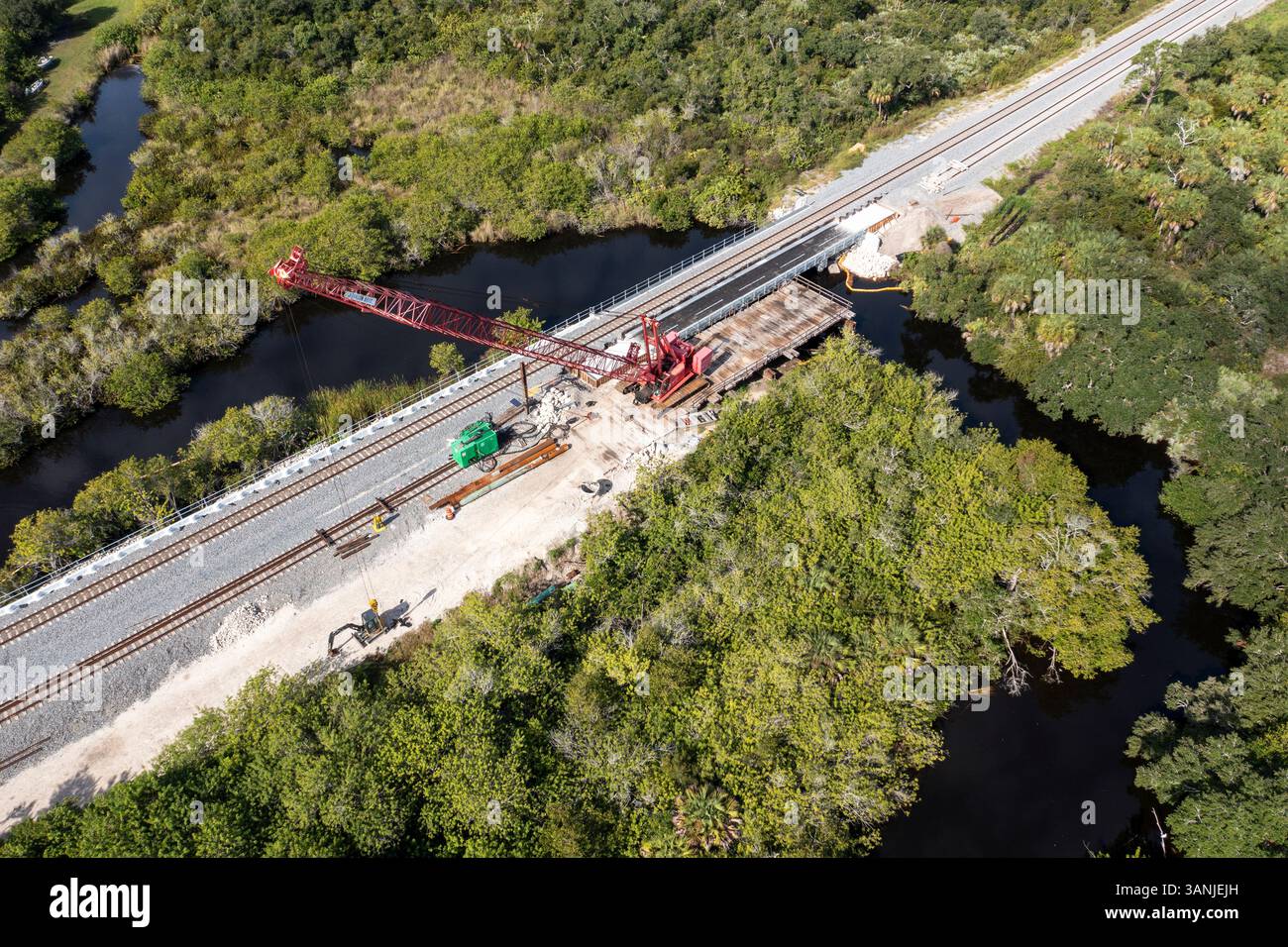 Aerial view of railroad bridge construction over Goat Creek surrounded ...