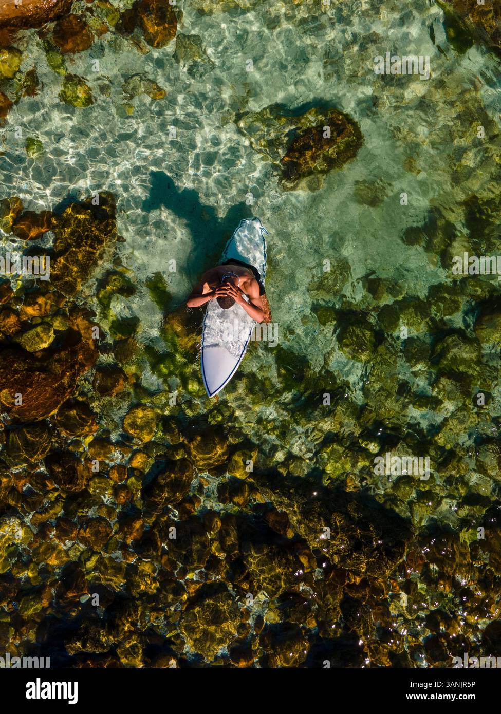 Aerial view of male on surfboard splashing face in Atlantic ocean top ...