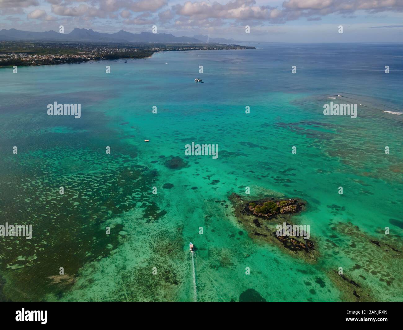 Aerial view of small fishing boat on crystal clear blue ocean, Pointe ...