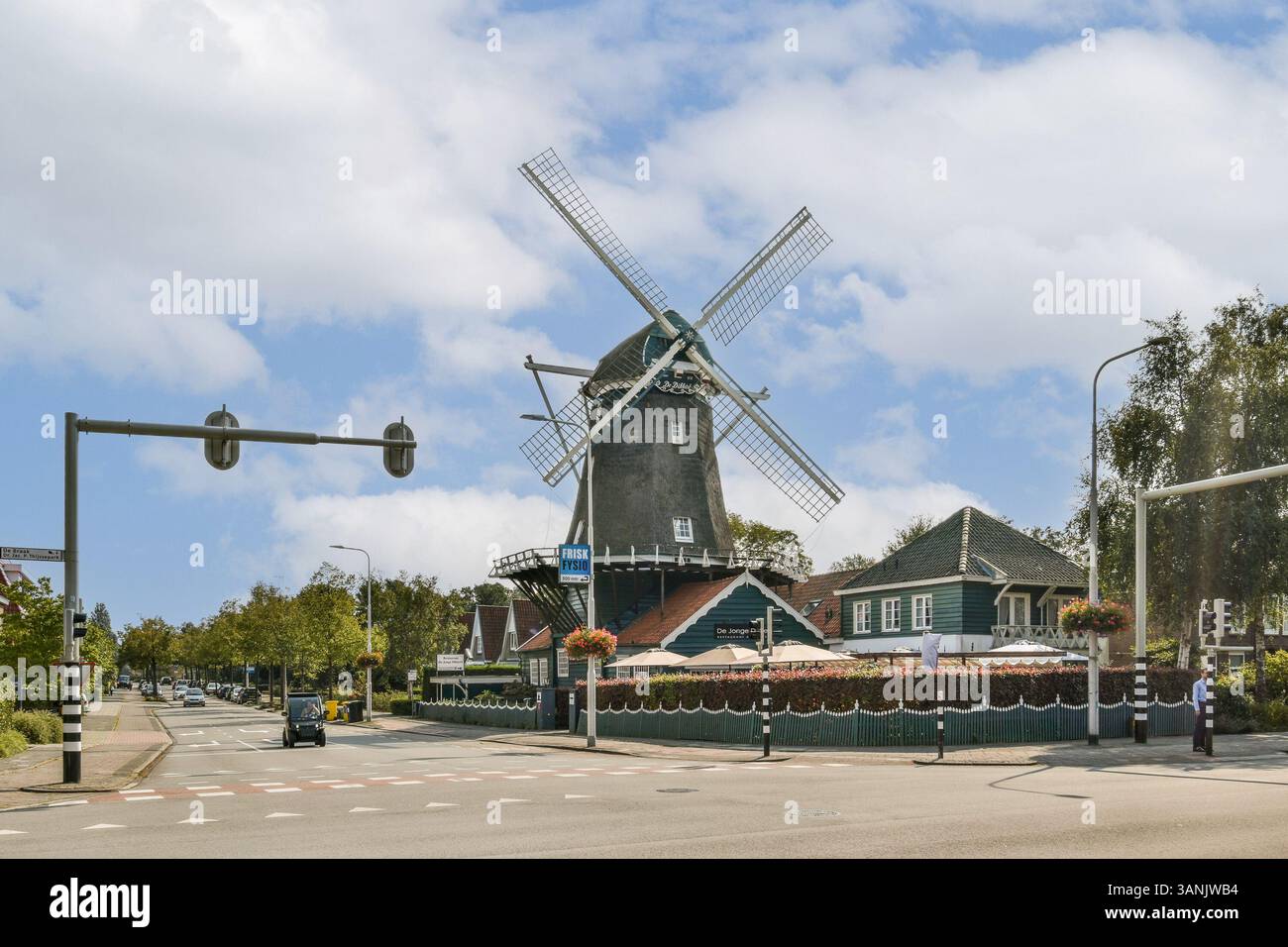 A picturesque view of a classic windmill set against a vibrant sky and ...