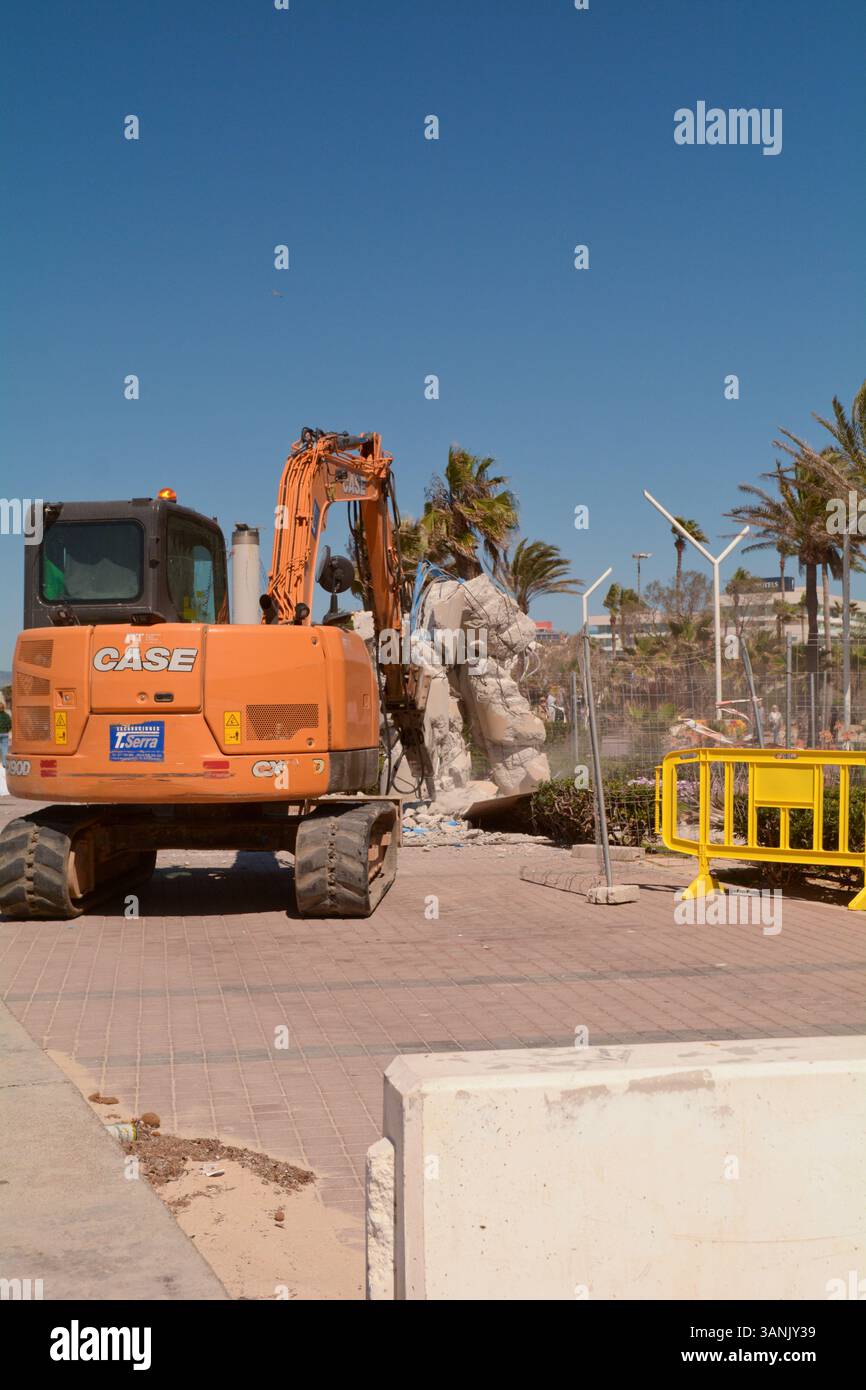 Construction workers using JCB machines to remove heavy concrete light ...