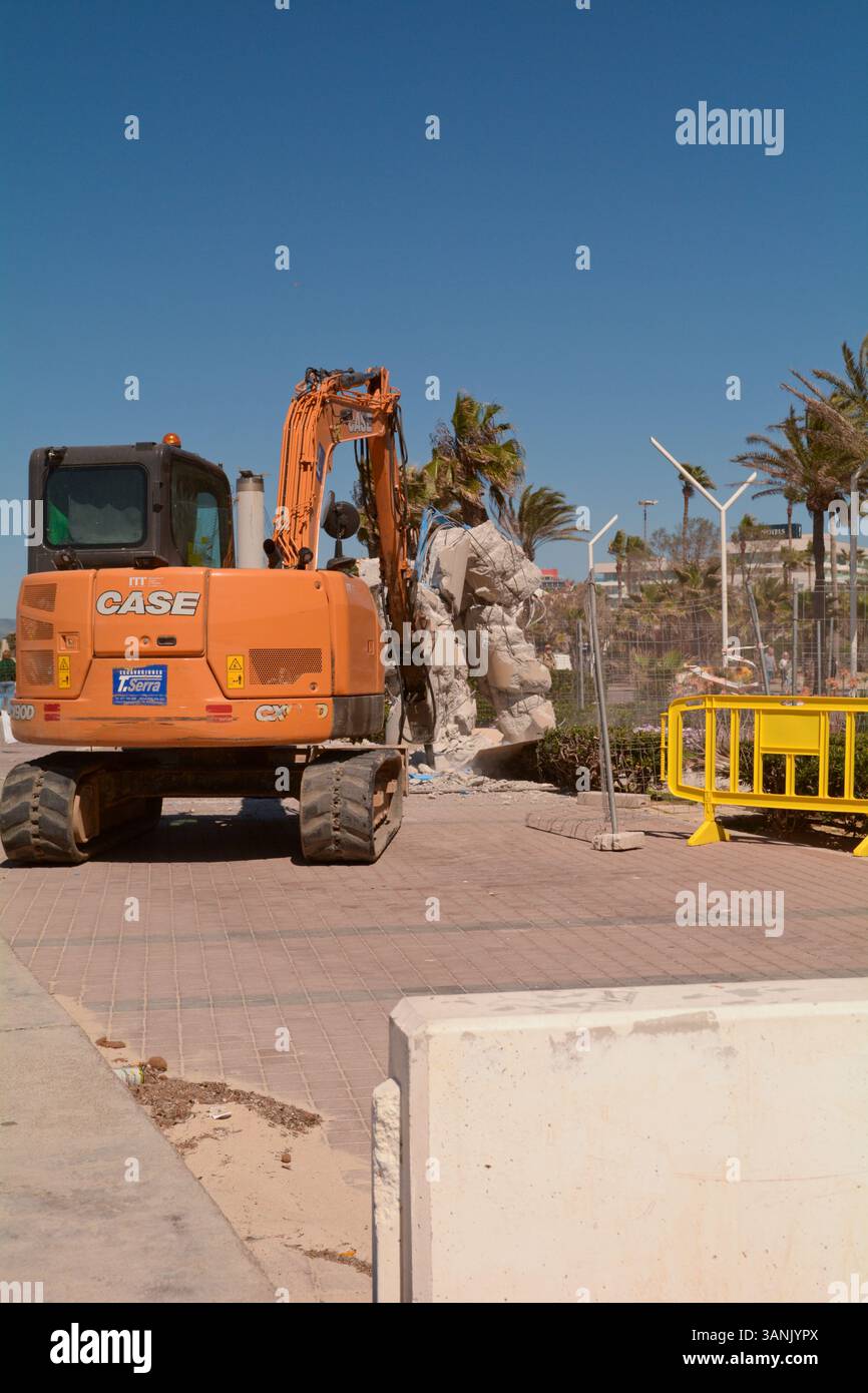 Construction workers using JCB machines to remove heavy concrete light ...
