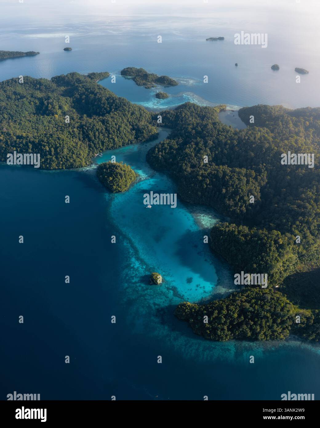 Aerial view of beautiful green islands and a sail boat in a pristine ...