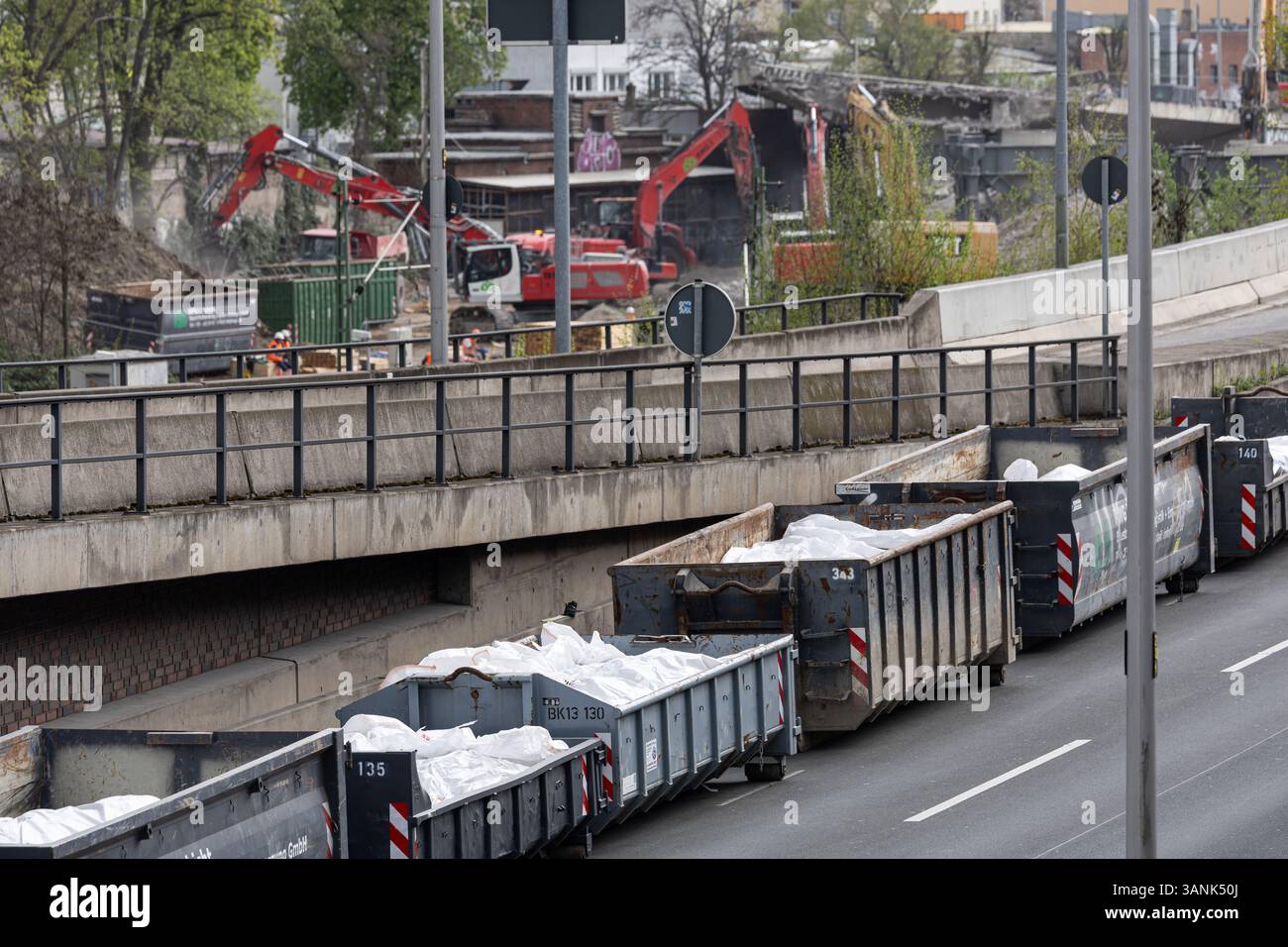 15 April 2025, Berlin: Containers of building rubble stand on a bridge ...