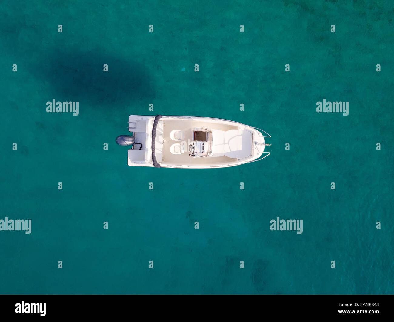 Aerial view of single speed boat floating over transparent water ...
