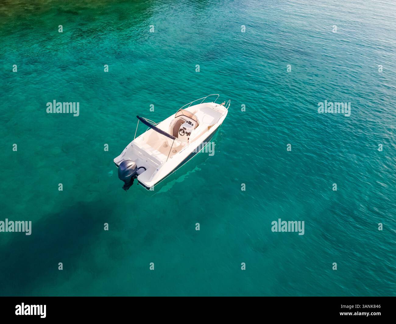 Aerial view of single speed boat floating over transparent water ...