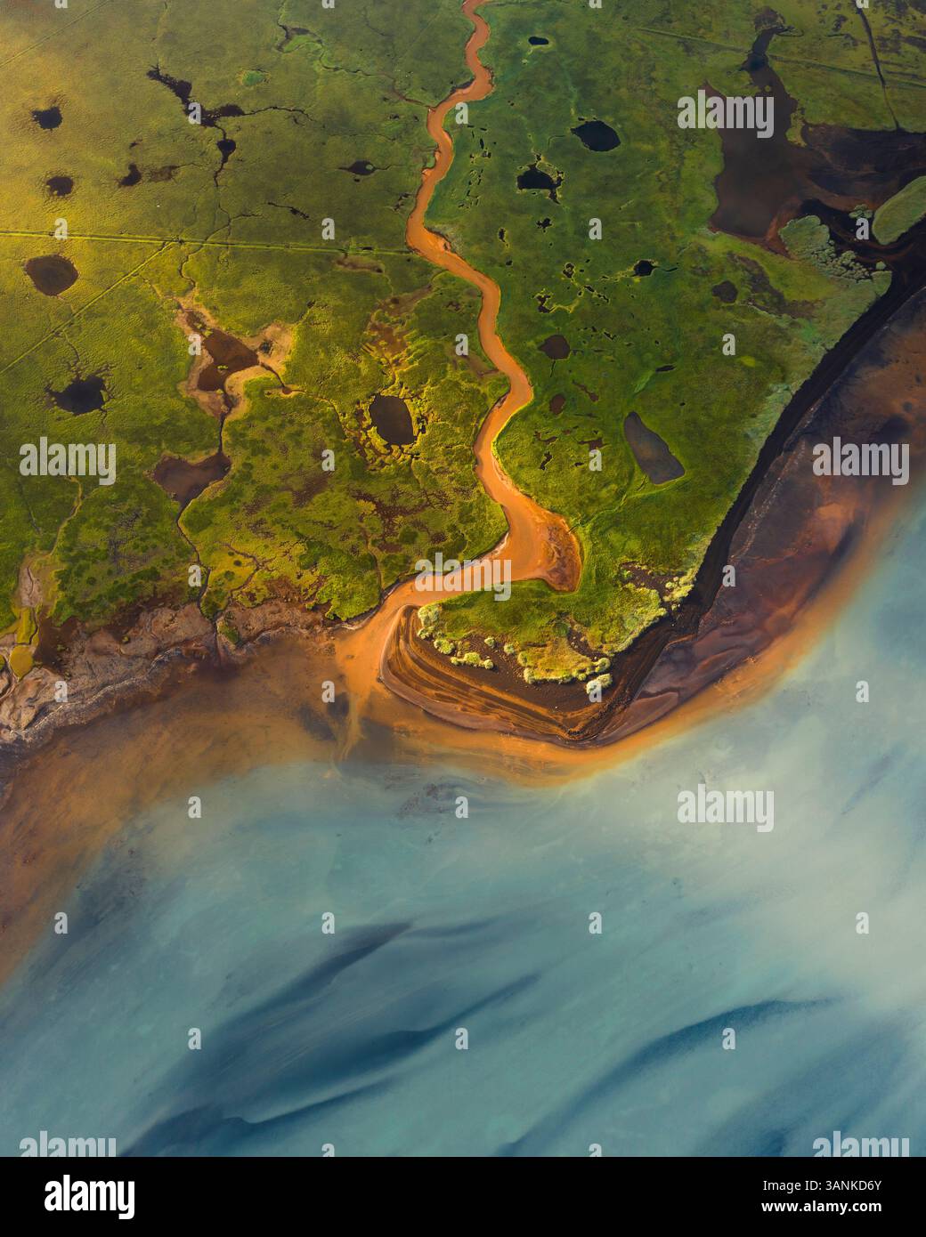 Aerial view of a lush green landscape with a meandering stream and ...