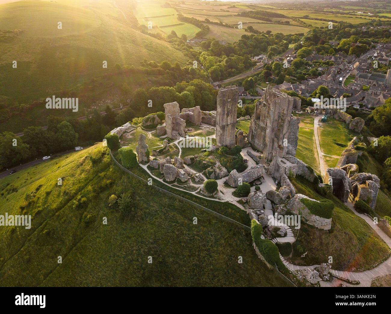 Aerial view of the historic ruins of Corfe Castle surrounded by a ...