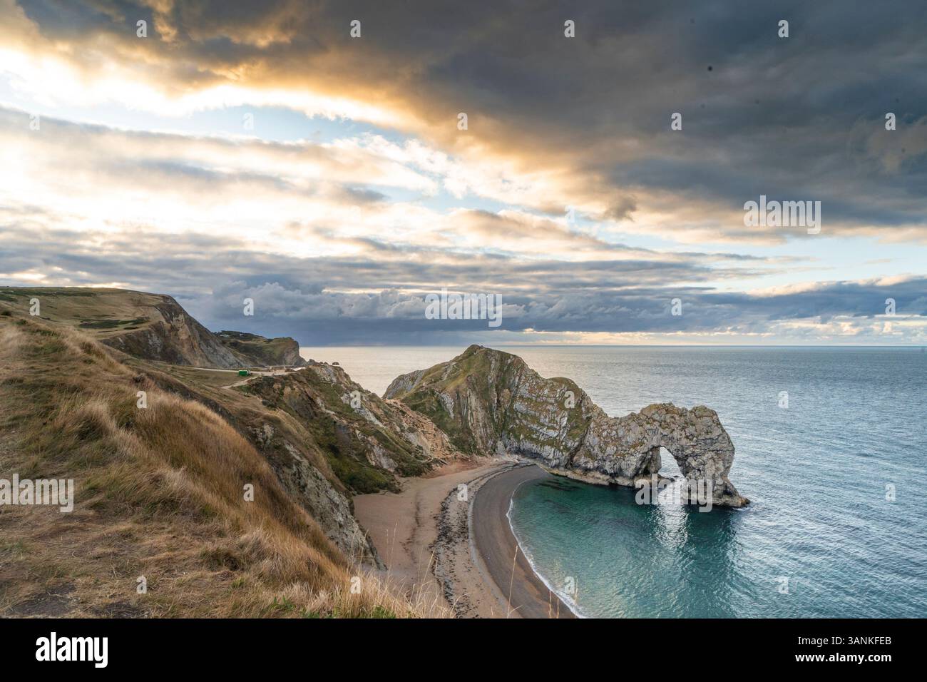 Aerial view of rugged cliffs and beautiful Durdle Door arch at sunset ...