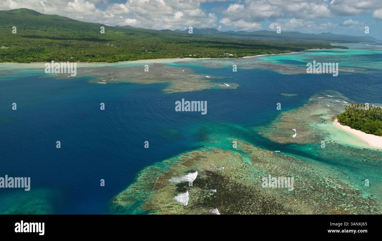 Aerial view of tropical paradise with clear water, coral reef, and lush ...