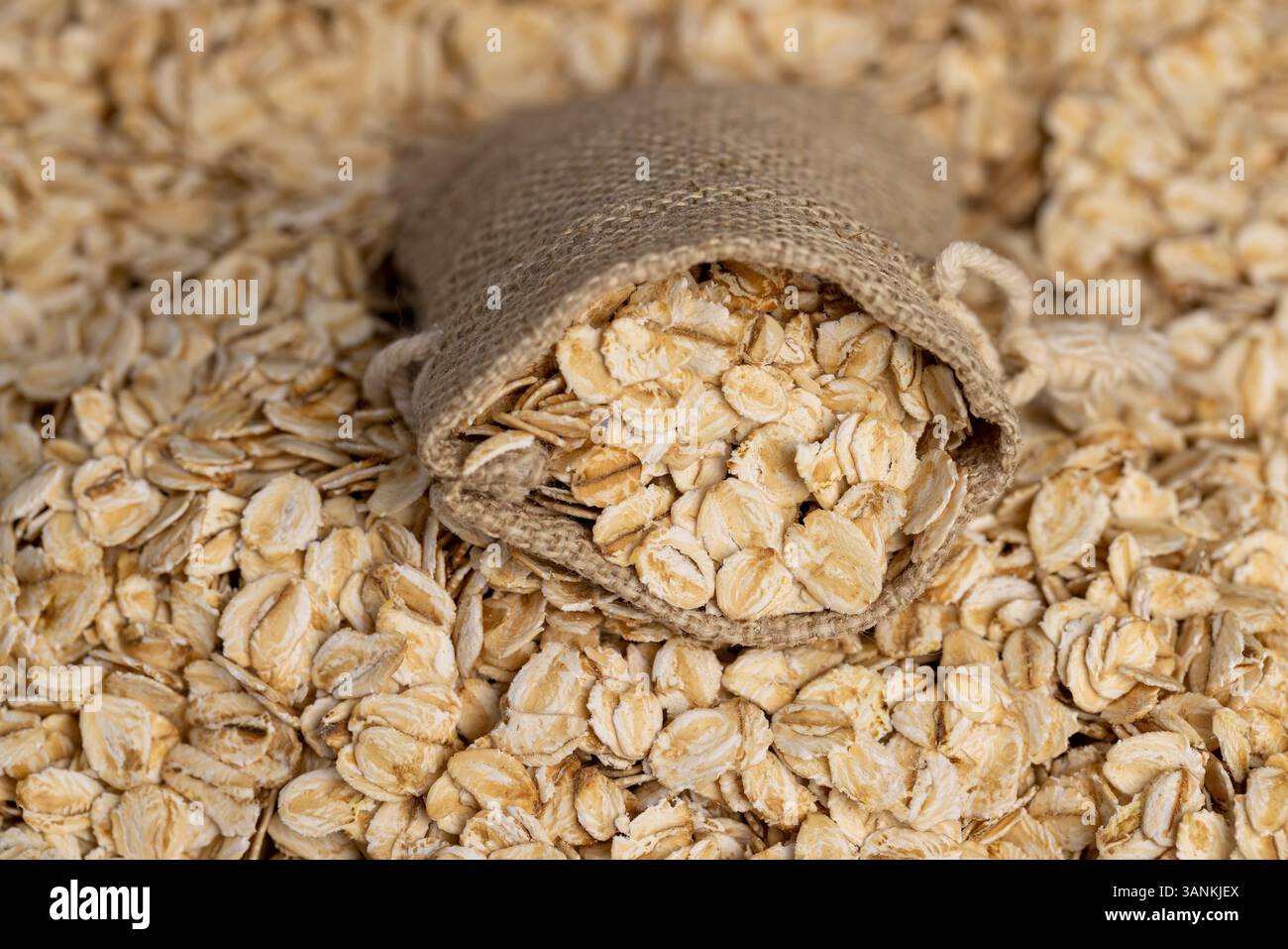 a linen bag with oatmeal flakes for porridge, scattered dry cereal ...