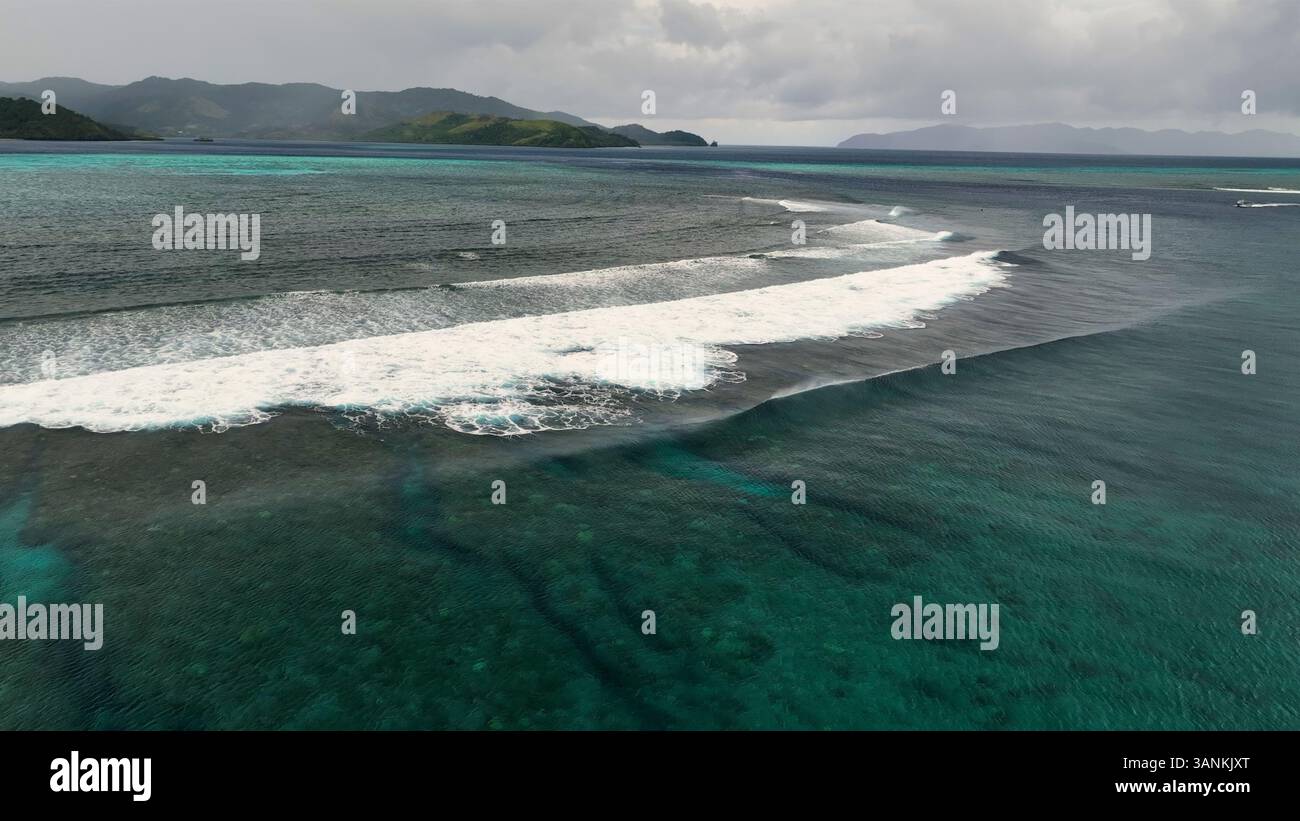 Aerial view of beautiful waves and coral reef in a tropical paradise ...