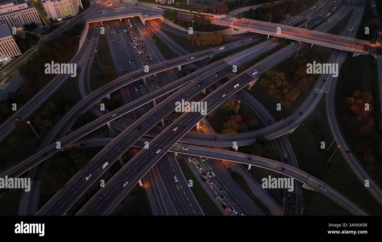 Aerial view of busy highway interchange with traffic and city lights at ...