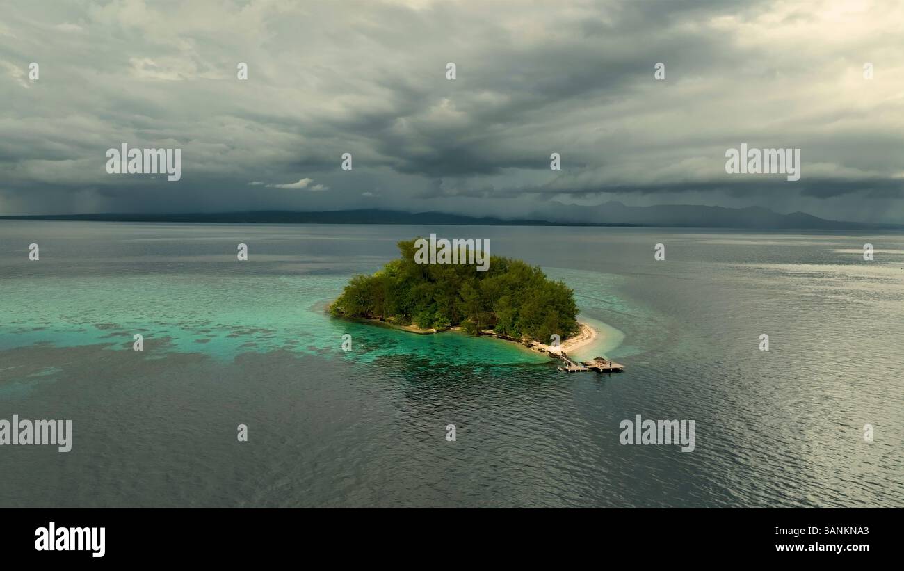 Aerial view of a tropical island with a pristine reef and stormy ocean ...