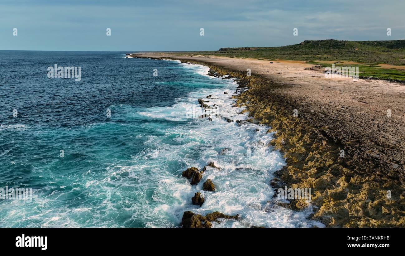 Aerial view of tropical reef and rocky coast with serene waves, Bonaire ...