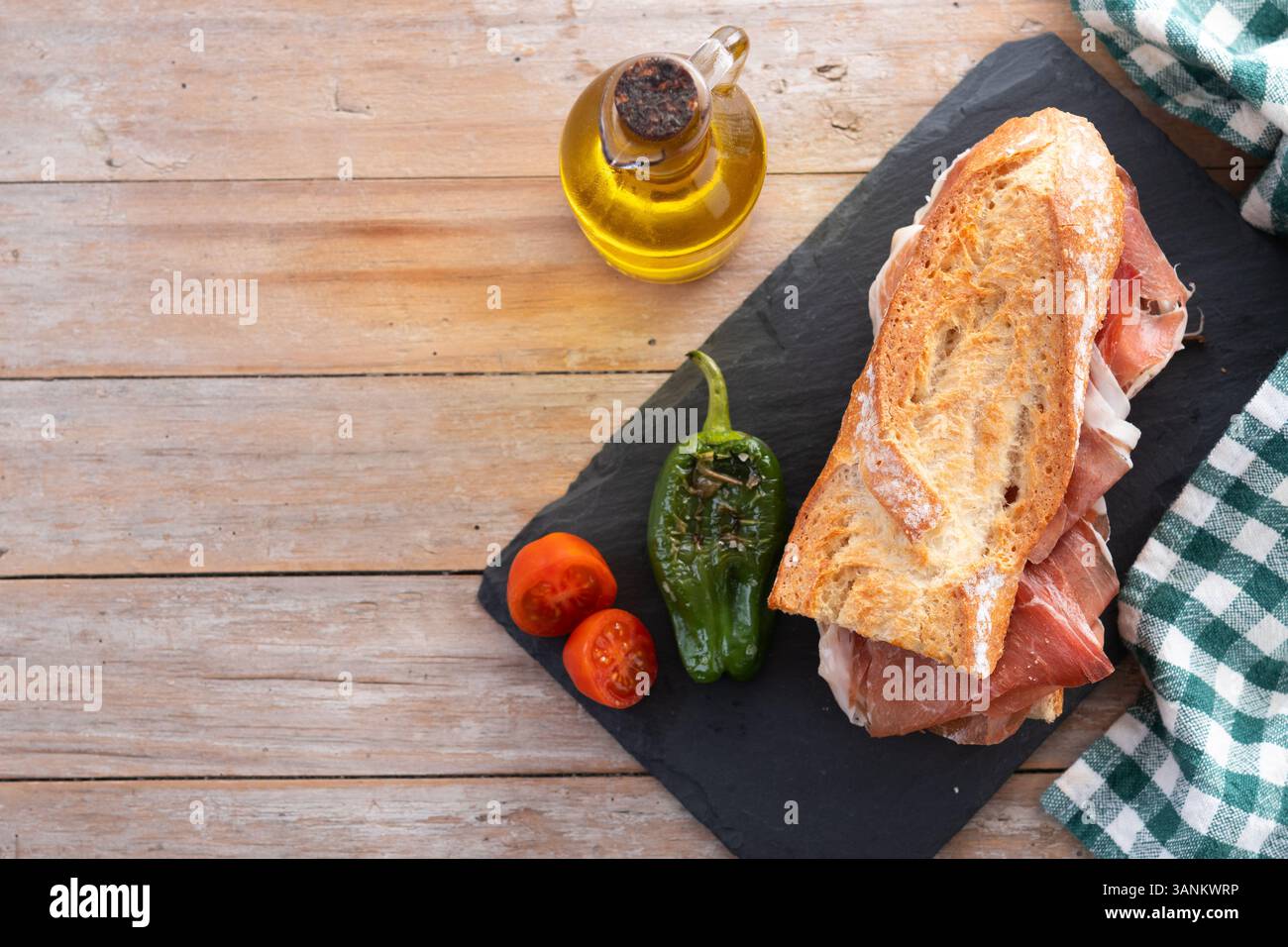 Spanish serrano ham sandwich on wooden table. Spanish bocadillo de ...
