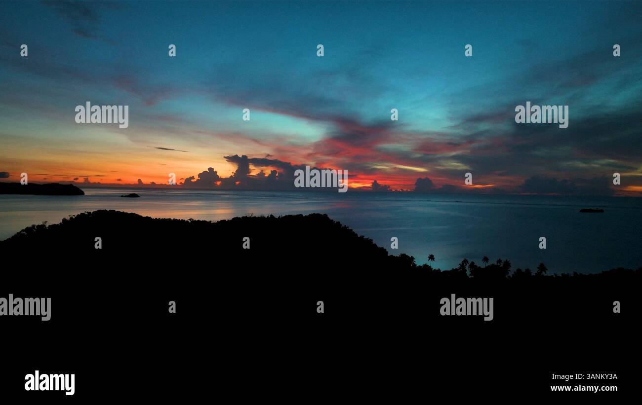 Aerial view of serene sunrise over island with tropical sky and calm ...