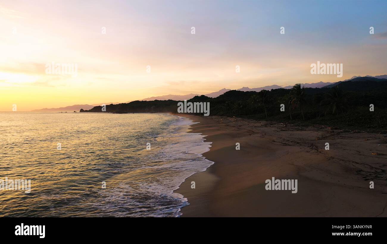 Aerial view of sunset over coastal beach with ocean waves, Santa Marta ...