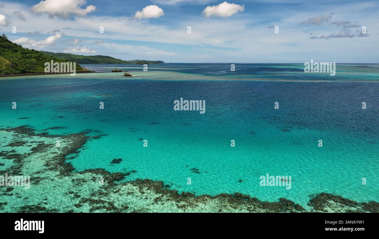 Aerial view of tropical island with clear water and coral reef, Eastern ...