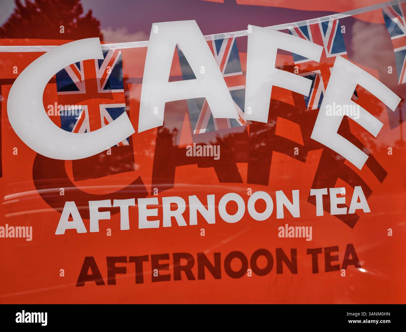 A red cafe window decorated in Uk British Union flags that serves ...
