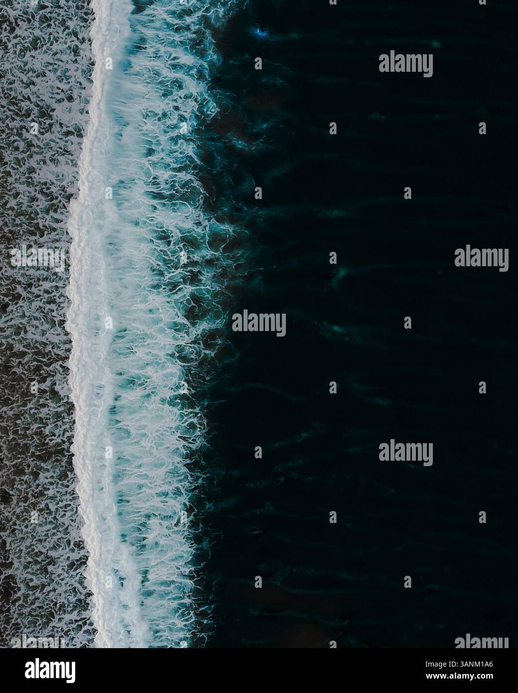 Aerial view of a wave crashing into a shallow lagoon reef in Maafushi ...