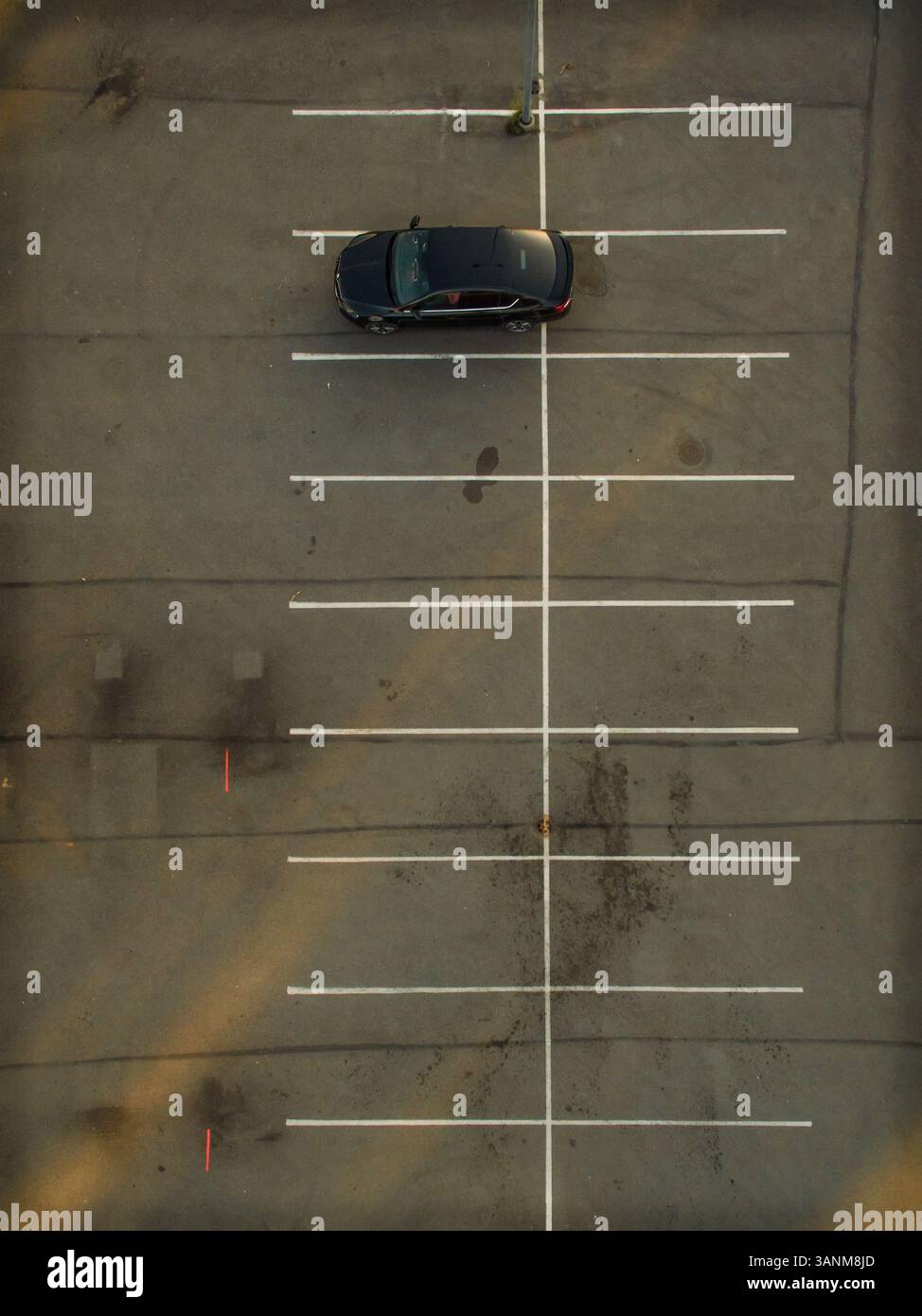 Aerial view of a car parked alone in a parking with sunset lights Stock ...