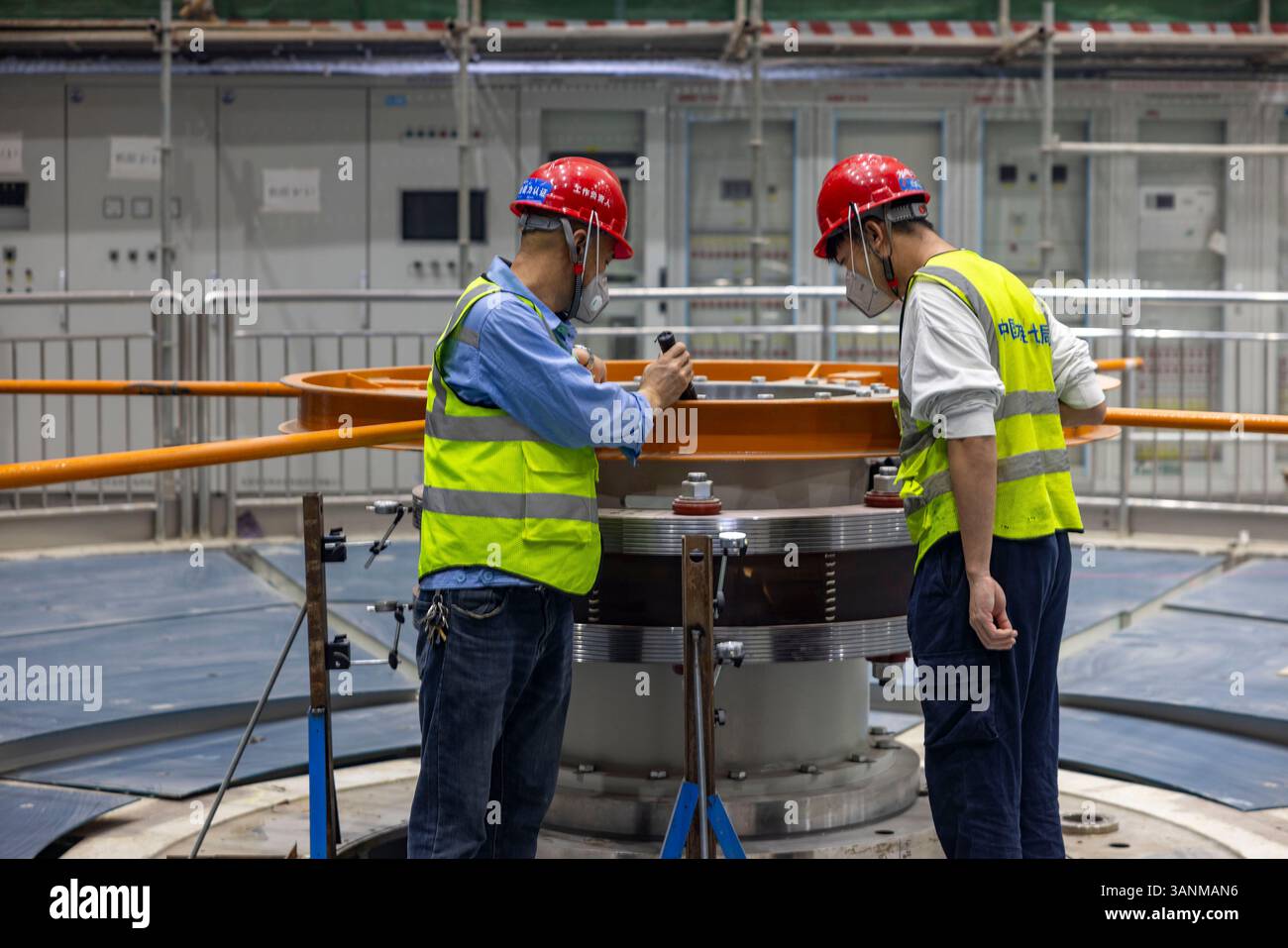 NANNING, CHINA - APRIL 15, 2025 - Builders inspect the generator ...