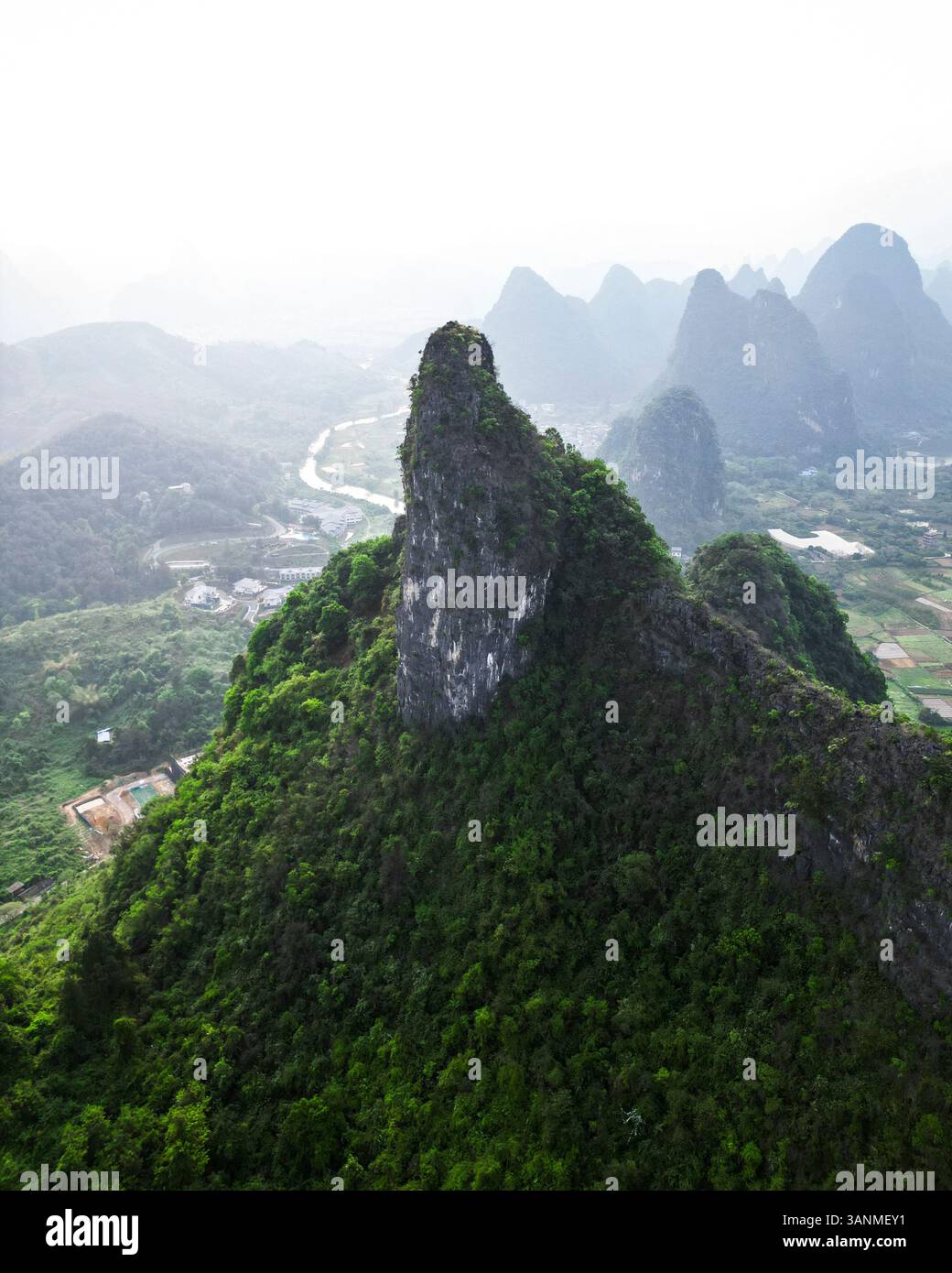 Aerial view of majestic karst mountains and lush valleys with misty ...