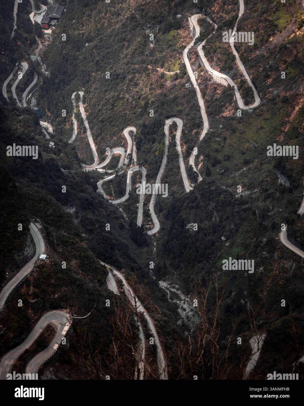 Aerial view of a winding road through majestic mountains and a scenic valley, Zhangjiajie, China ...