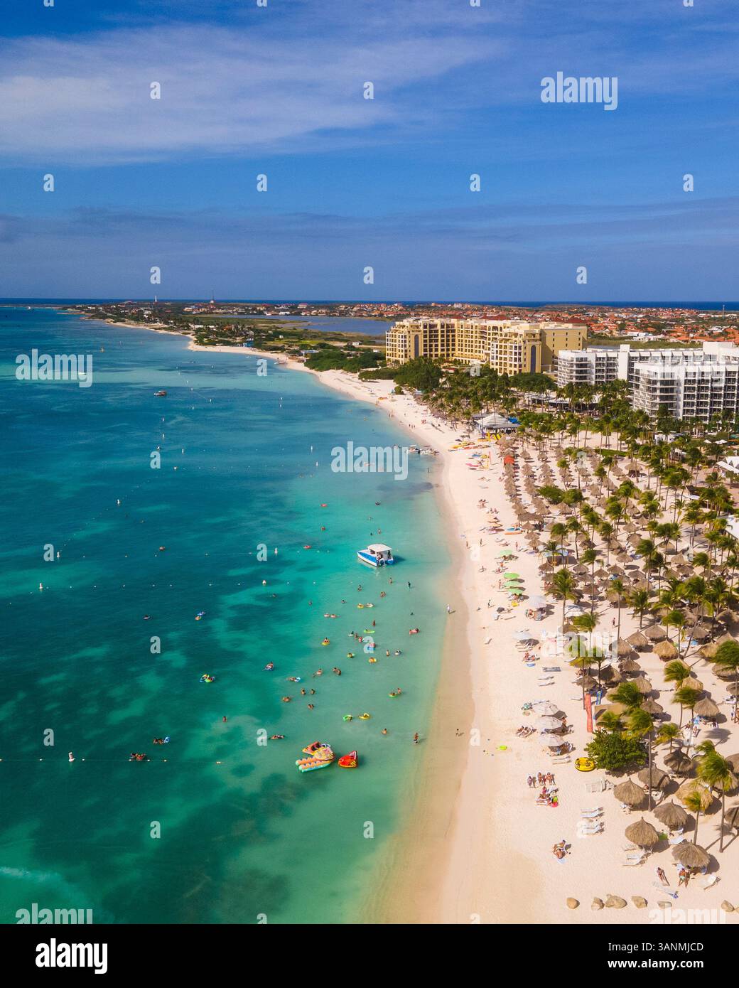 Aerial view of people on the beach along the shoreline with hotel ...