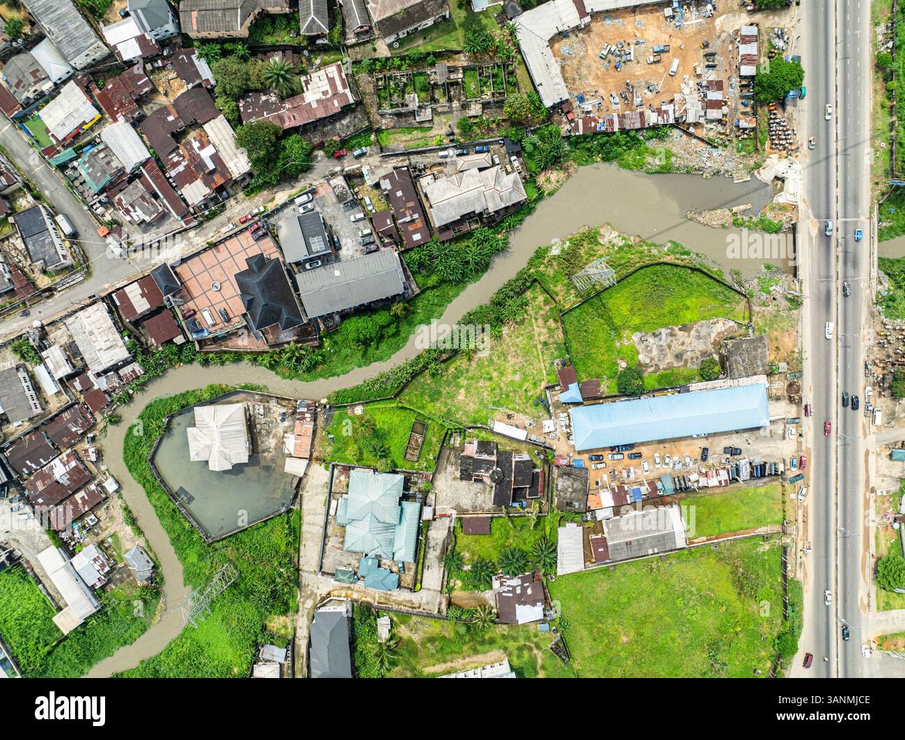 Aerial view of residential buildings and roads alongside a river with ...