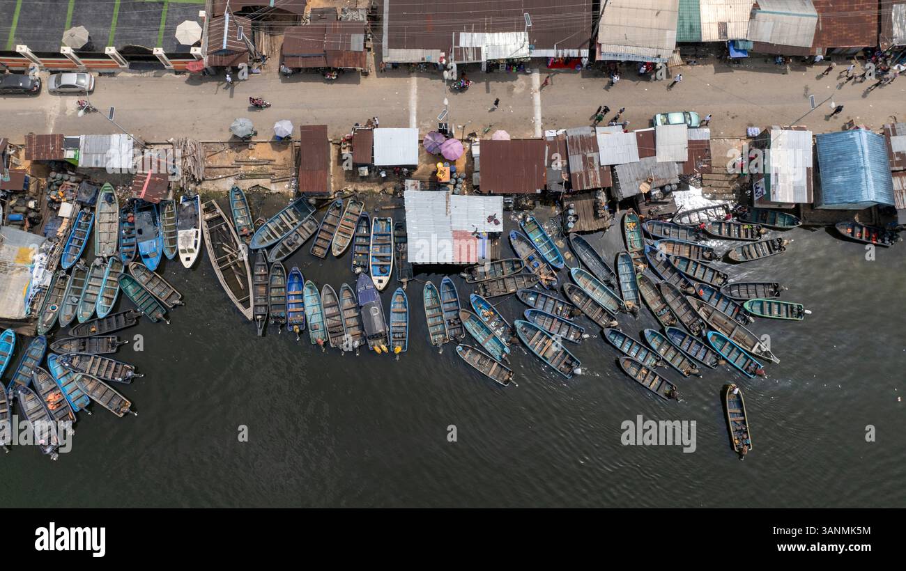 Aerial view of busy fishing boats and traditional wooden docks along a ...