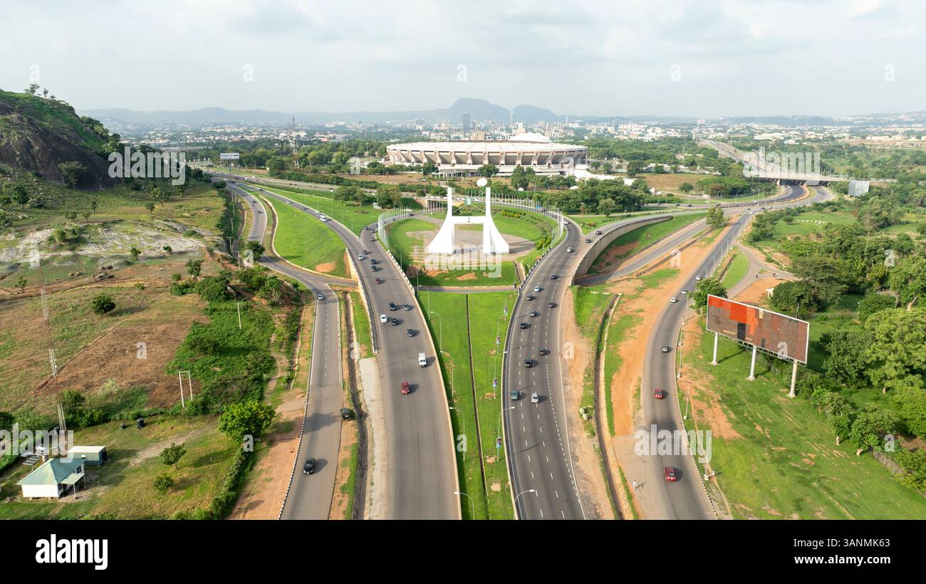 Aerial view of bustling city gate and highway with cars and greenery ...