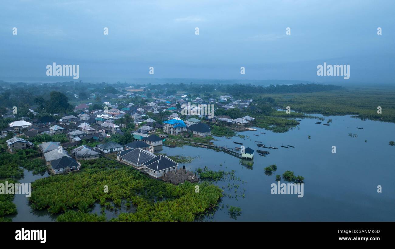 Aerial view of a tranquil waterside village with lush greenery and ...