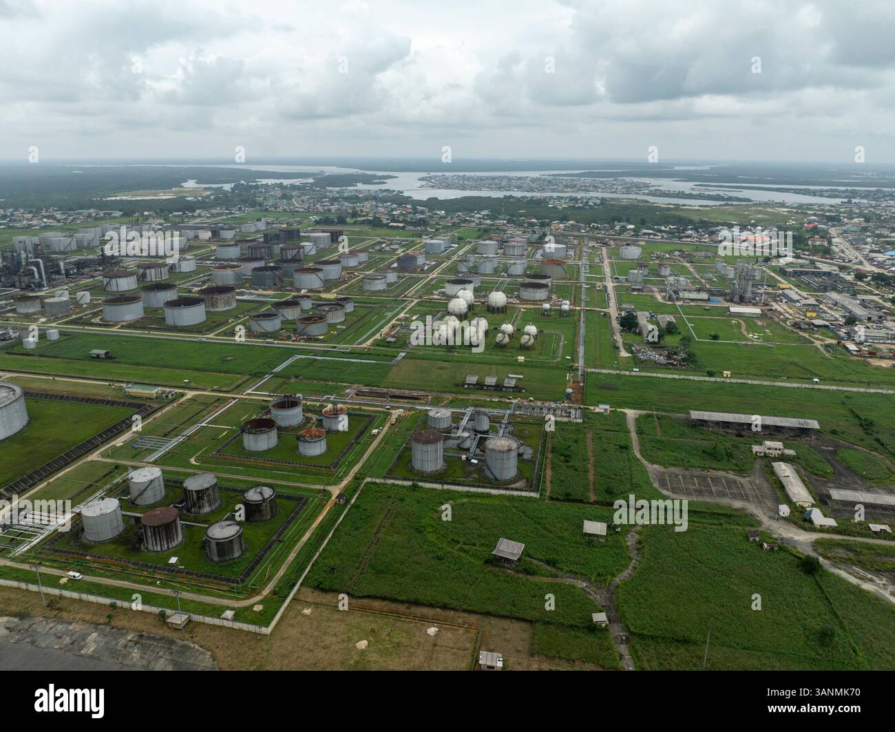 Aerial view of an industrial refinery complex with oil tanks and urban ...