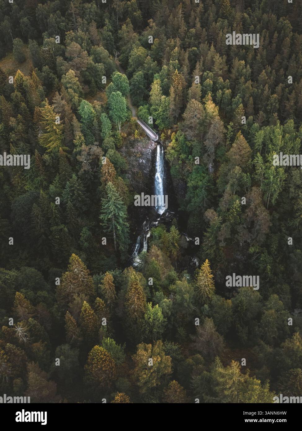 Aerial view of Plodda Falls cascading through lush forest, Scotland ...